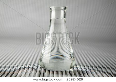 a chemist or medical research scientist adds chemicals to a erlenmeyer ...